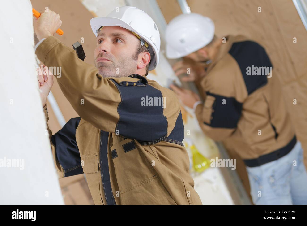 builder using a hammer and chisel at a construction site Stock Photo ...