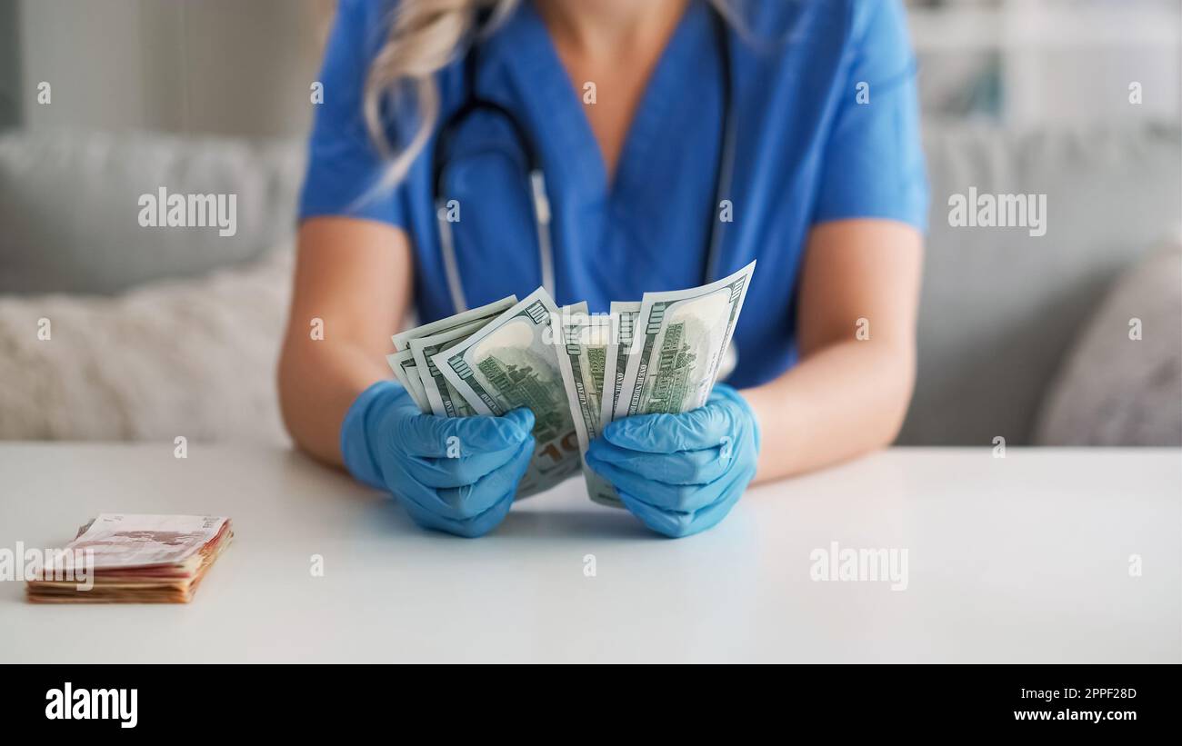 Doctor counting 100 us dollar hi-res stock photography and images - Alamy