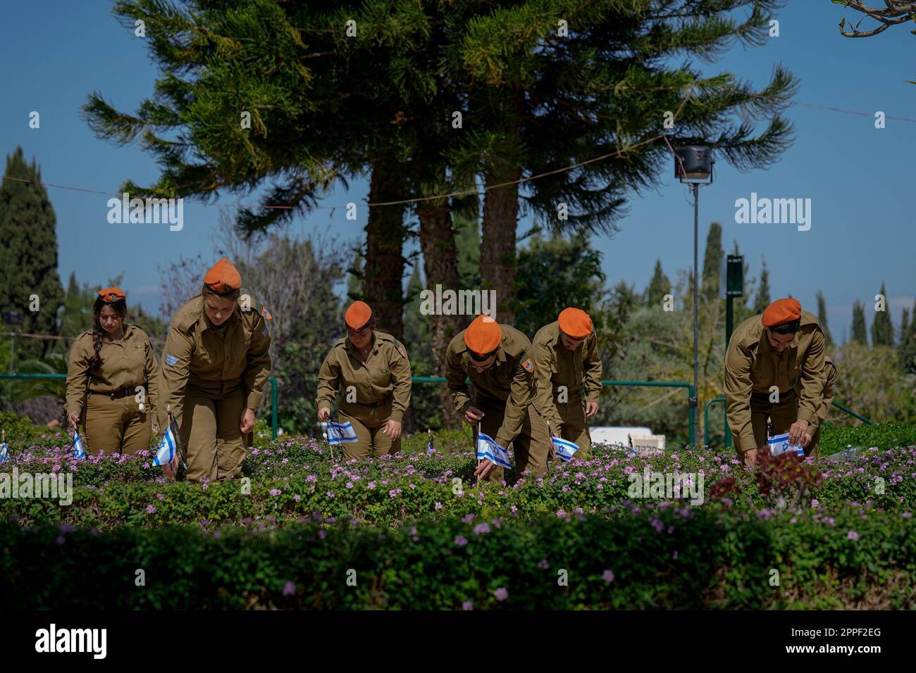 Israeli soldiers places flags with black ribbons on soldiers graves ...