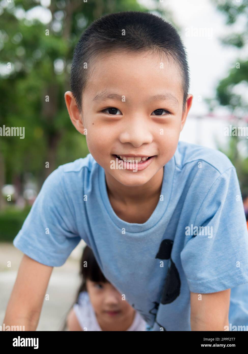 Happy asian boy playing on playground, sister is behind him Stock Photo ...