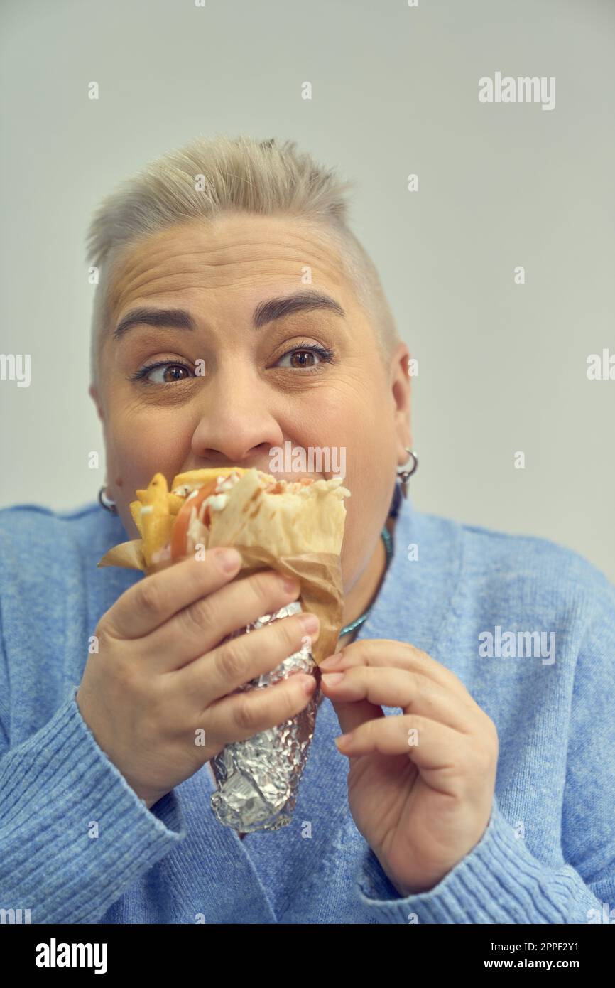 Funny adult woman chewing a sandwich. White female person with short ...
