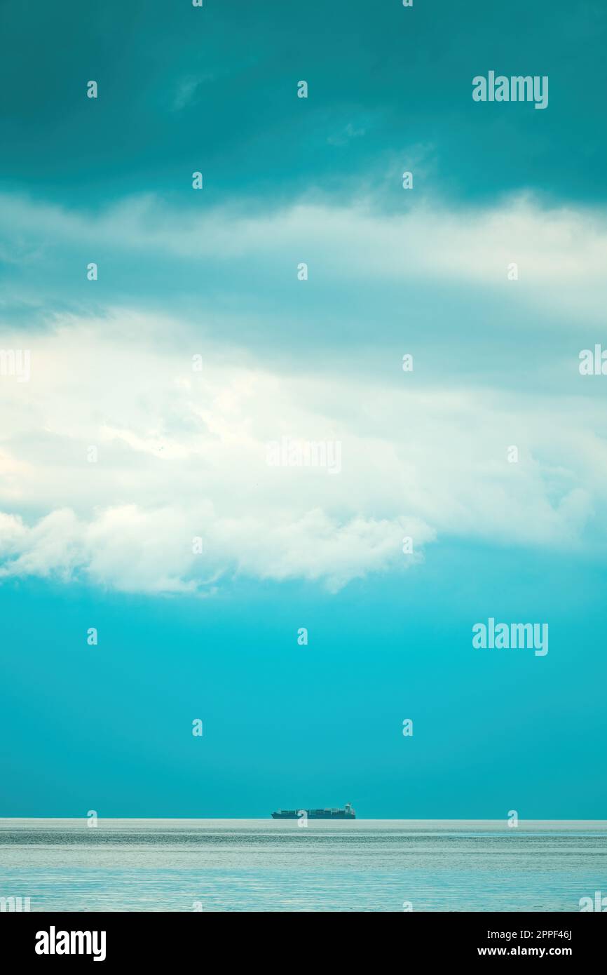 Large container ship sailing at sea in overcast morning, selective ...