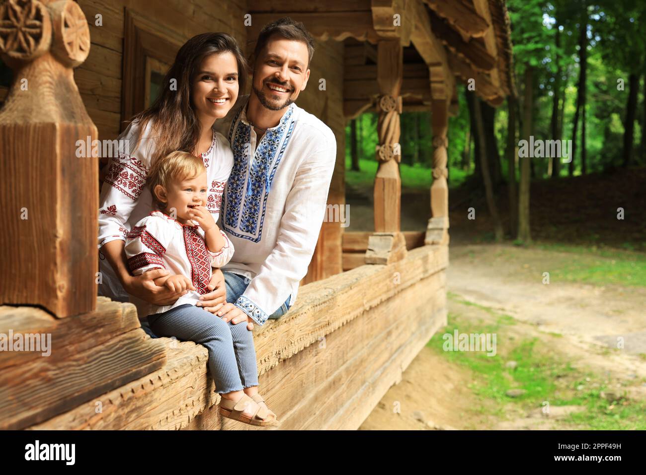 Happy family in Ukrainian national clothes on wooden terrace Stock ...