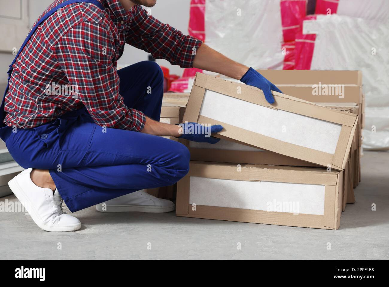 Construction worker with packed new boxes in room prepared for ...