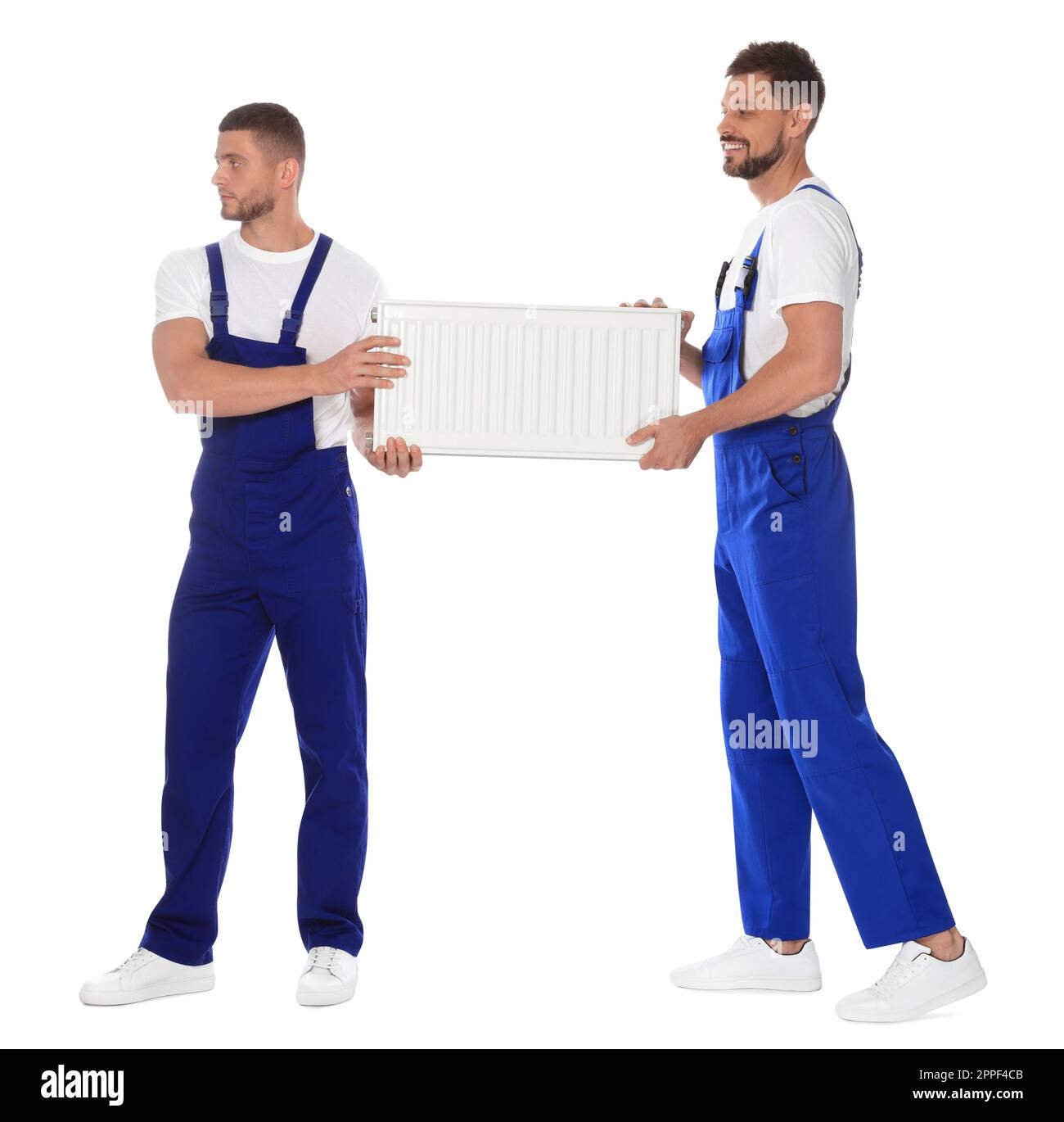 Professional plumbers with new heating radiator on white background ...