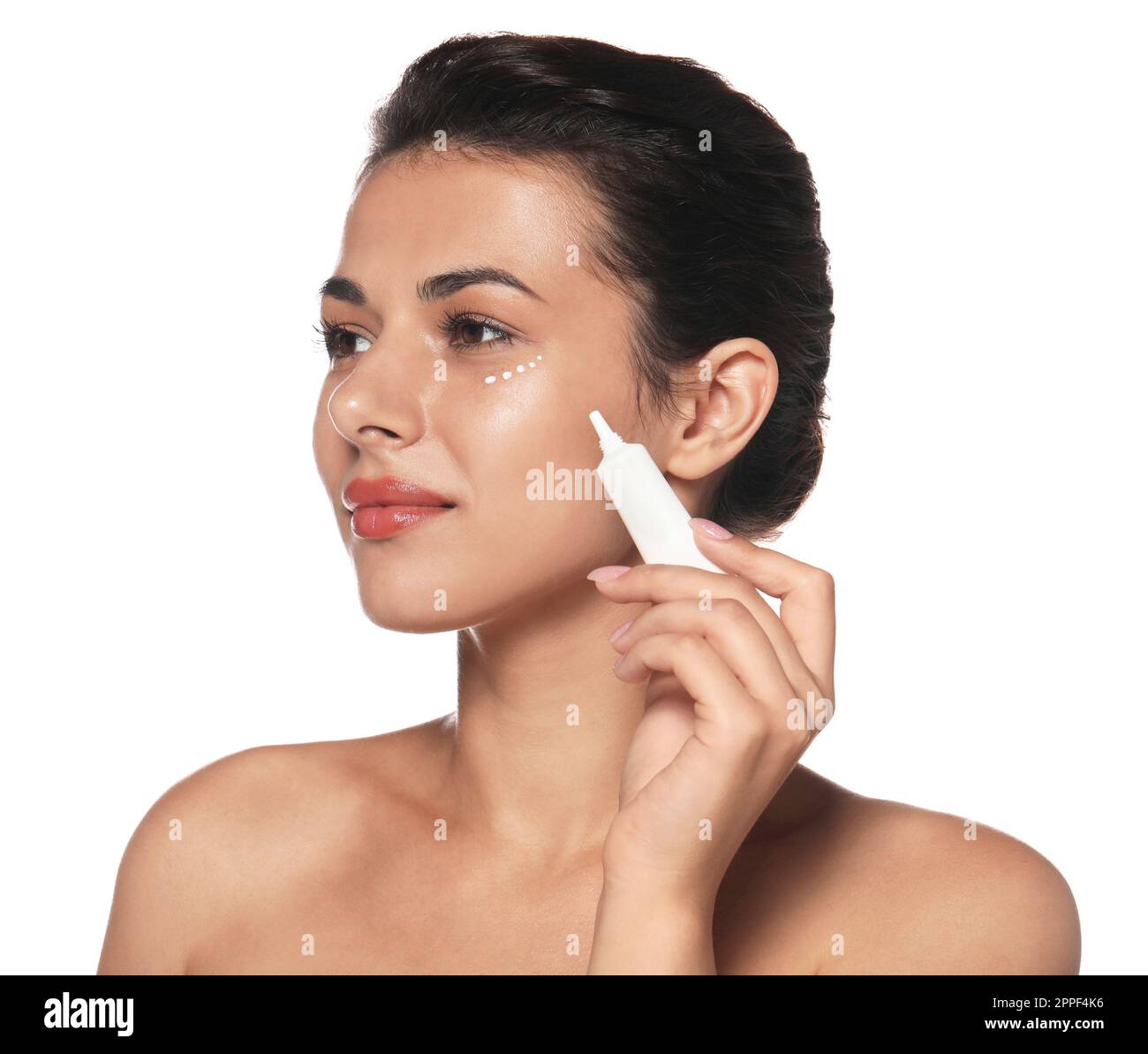 Woman applying cream under eyes on white background. Skin care Stock ...