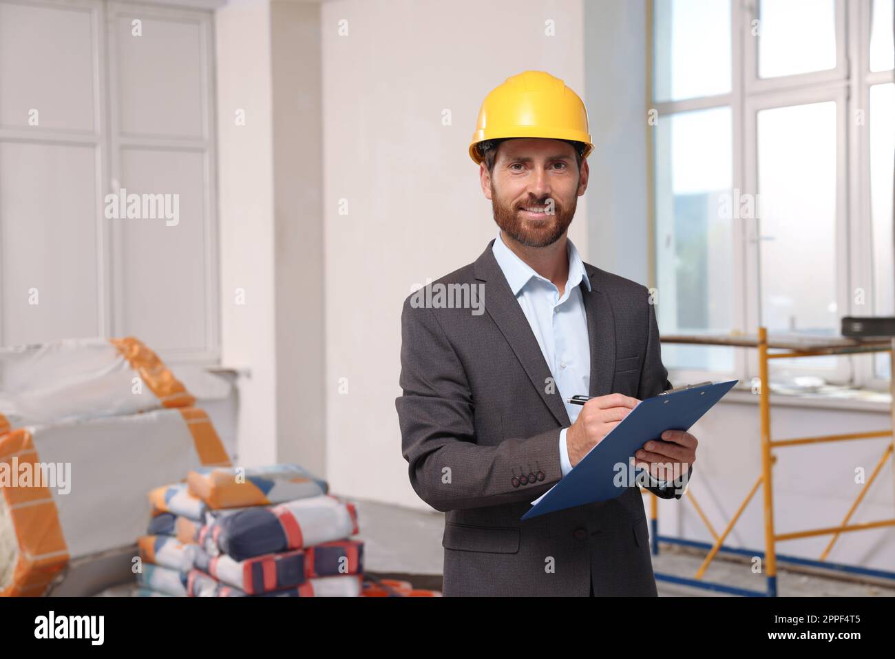 Professional engineer in hard hat with clipboard indoors Stock Photo ...