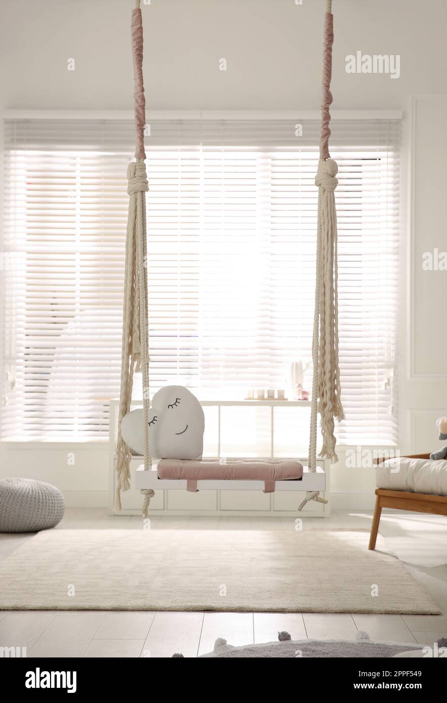 Beautiful swing with toy heart in room. Stylish interior design Stock ...