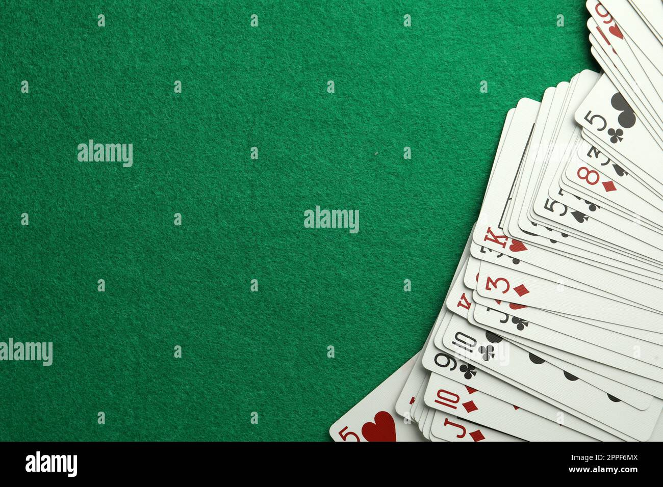 Deck of playing cards on green table, top view. Space for text Stock ...
