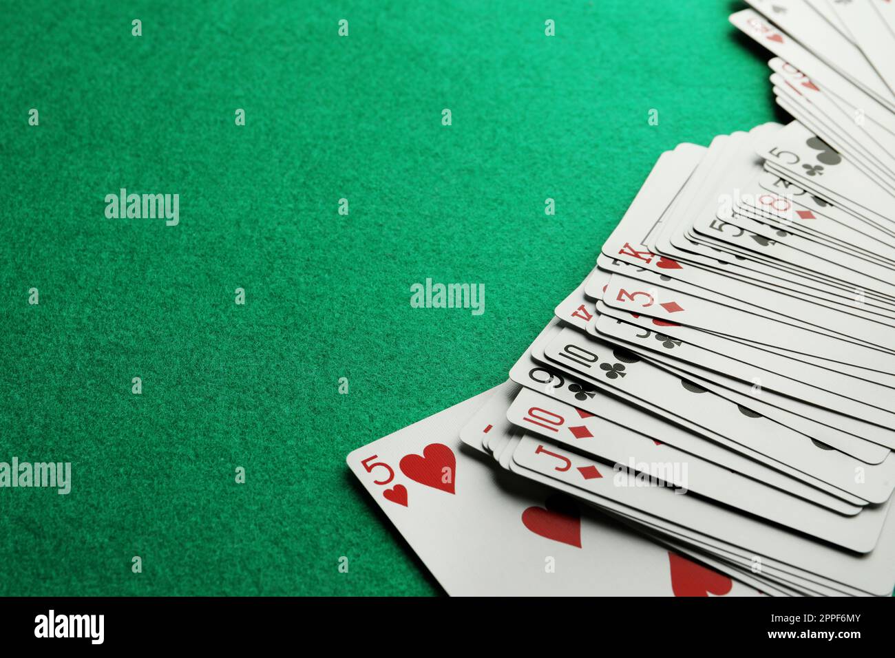 Deck of playing cards on green table, closeup. Space for text Stock ...