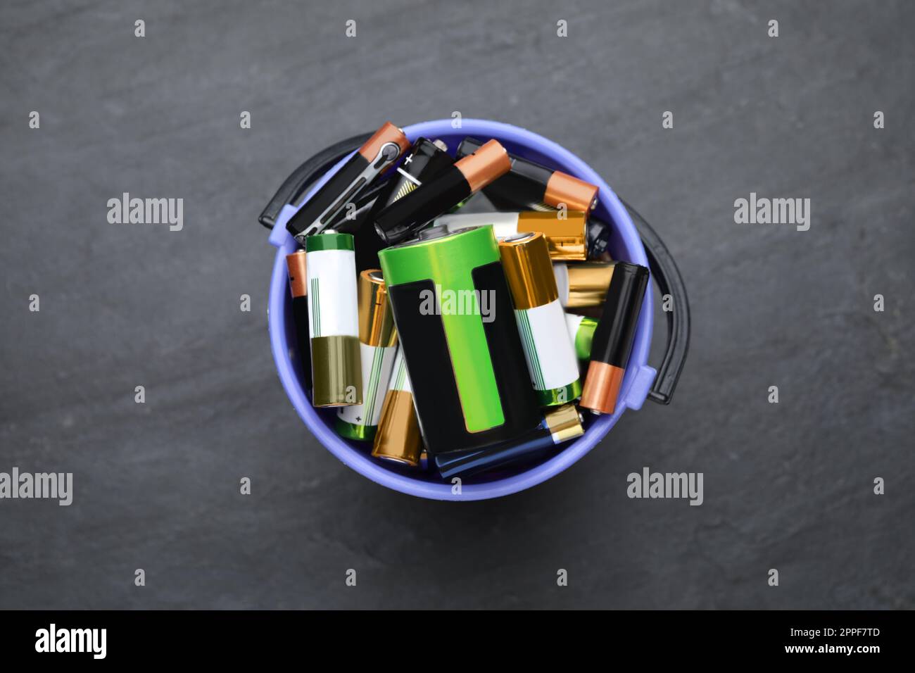 Used batteries in bucket on black table, top view Stock Photo - Alamy