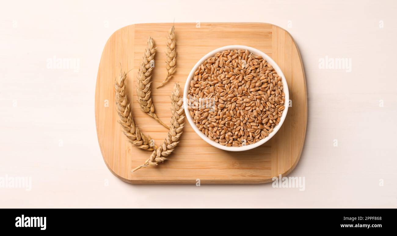 Wheat grains with spikelets on white table, top view Stock Photo - Alamy
