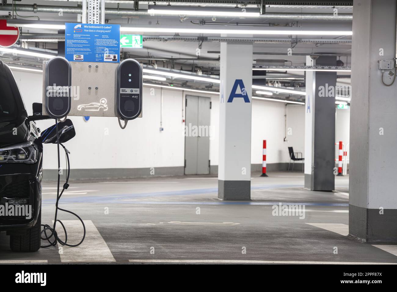 Electric car charging station in underground parking lot with BMW ...