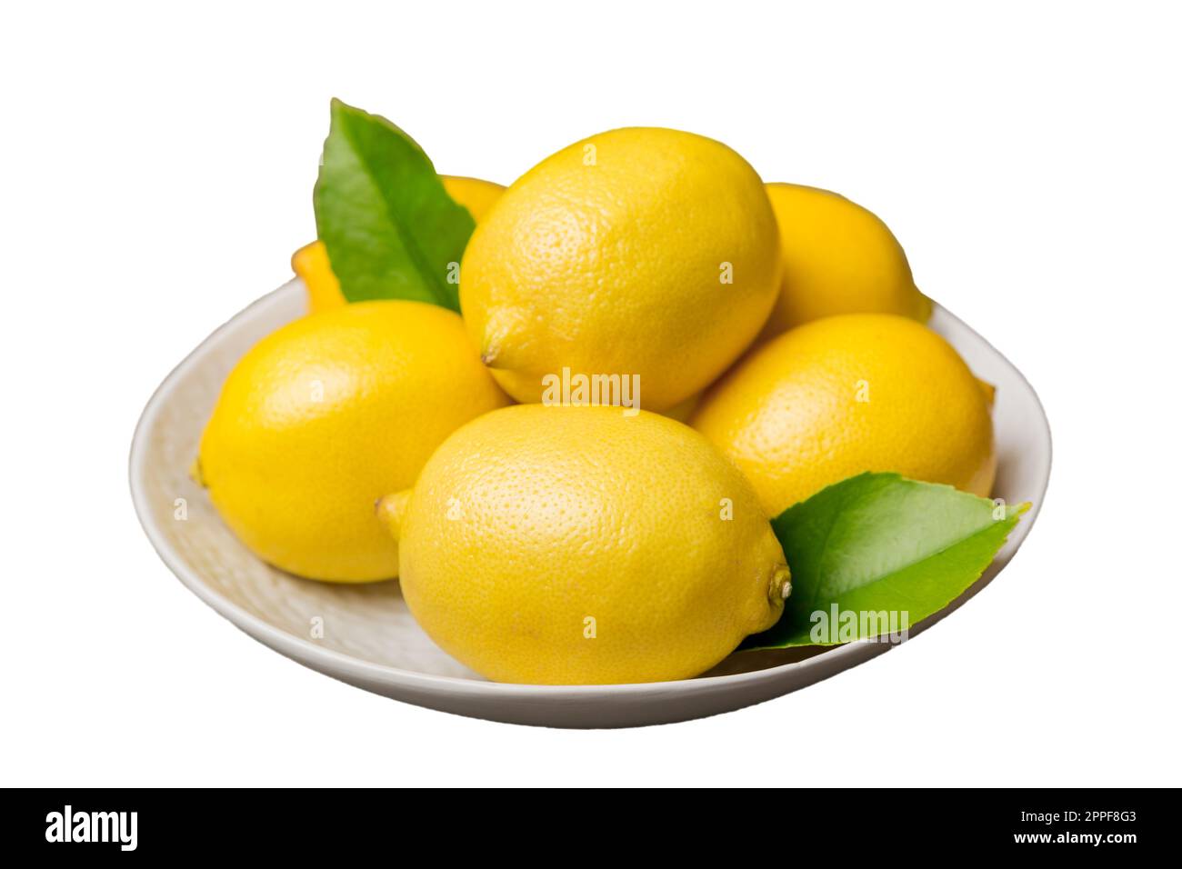 Fresh cutted lemon and whole lemons over round plate isolated on white ...