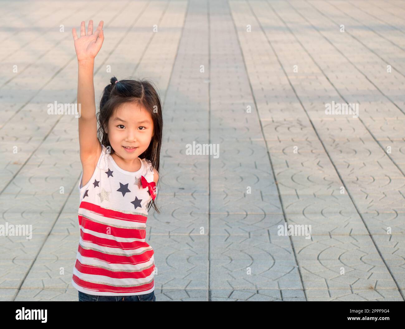 portrait of asia young girl cheering with raised arm, in sun set light ...