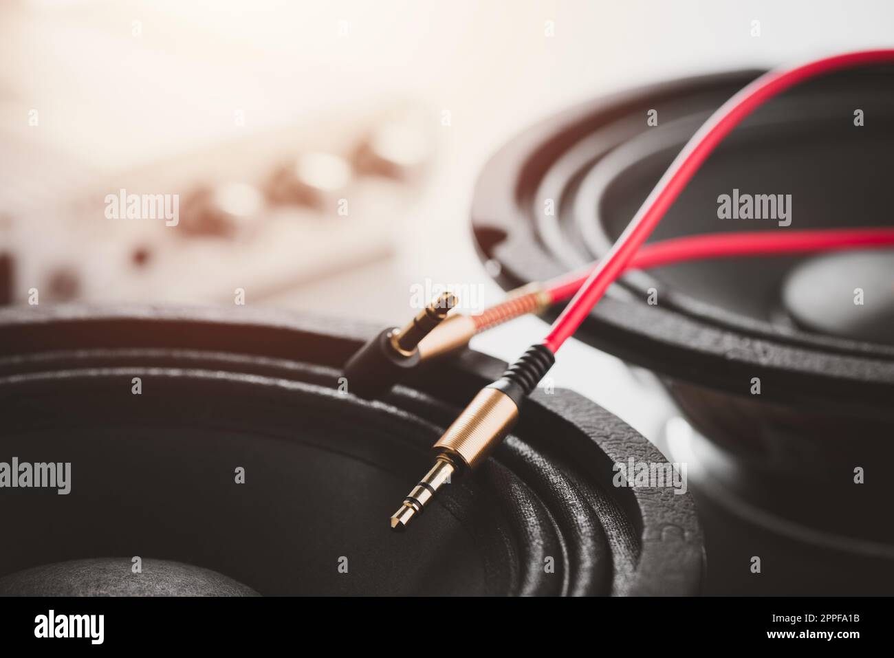 Close up red AUX(Auxiliary) cable with Male jack with speaker in the ...