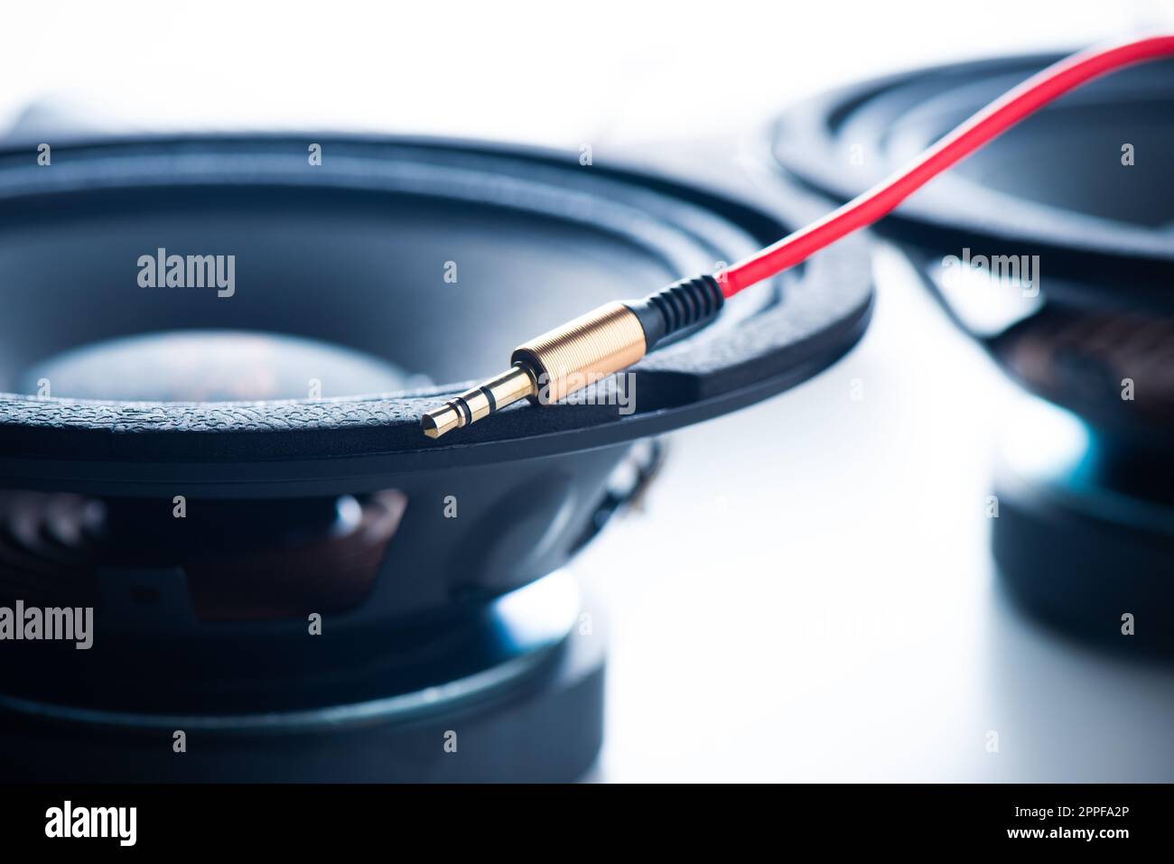 Close up red AUX(Auxiliary) cable with Male jack with speaker in the ...