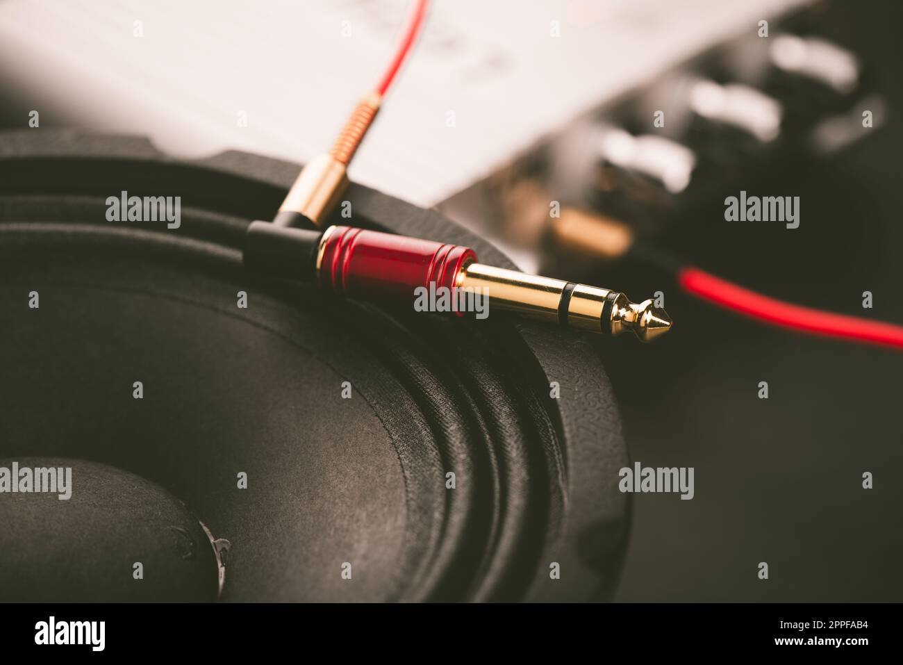 Close up red AUX(Auxiliary) cable with Male jack with speaker in the ...