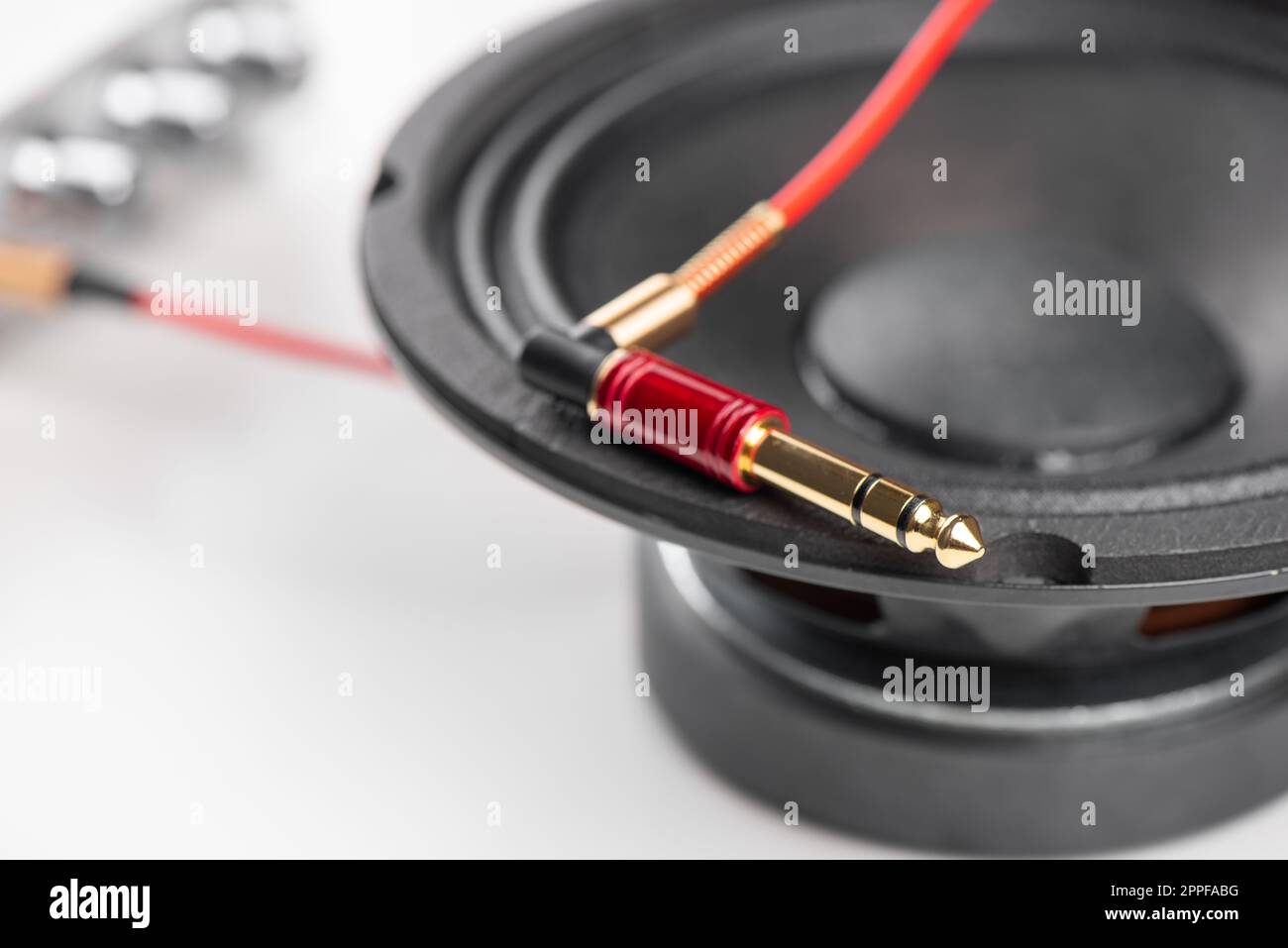 Close up red AUX(Auxiliary) cable with Male jack with speaker in the ...