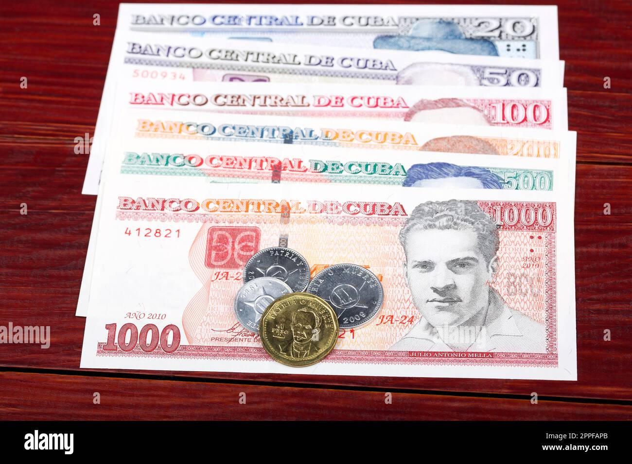 Cuban Pesos coins and banknotes on a wooden background Stock Photo - Alamy