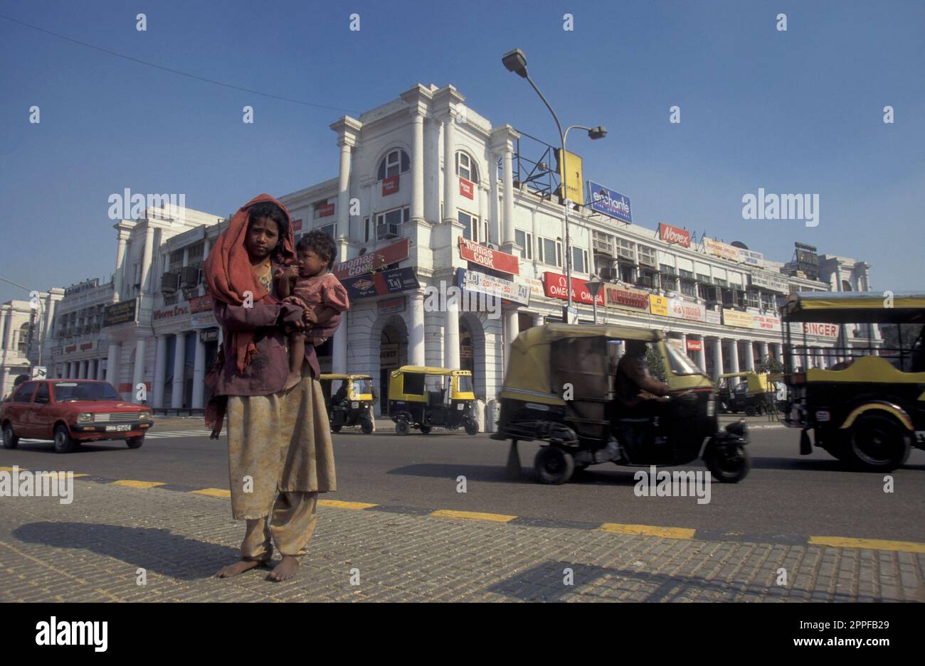 a poor women with child at the shopping area of Connaught Place in the ...