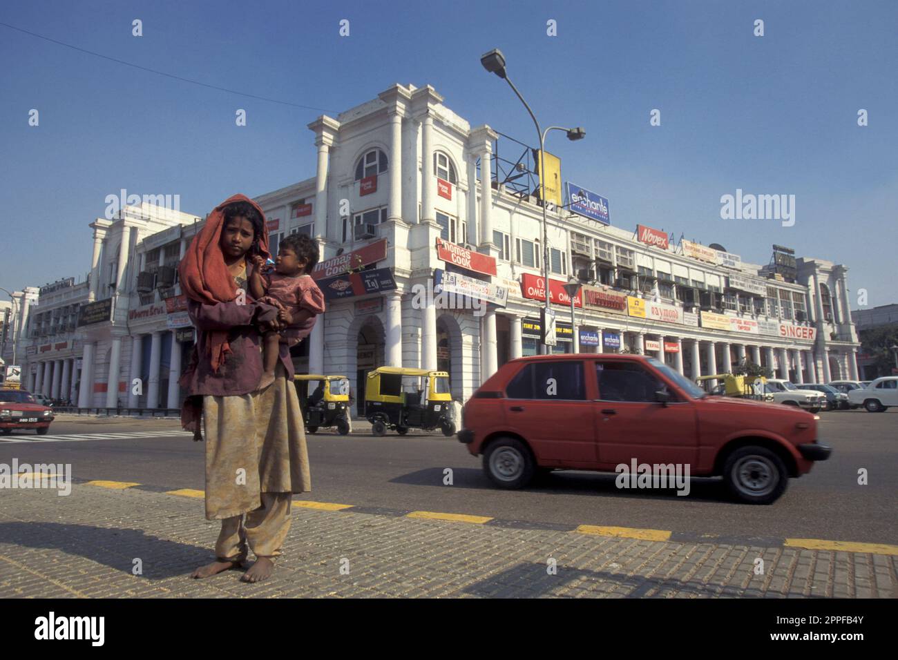 a poor women with child at the shopping area of Connaught Place in the ...
