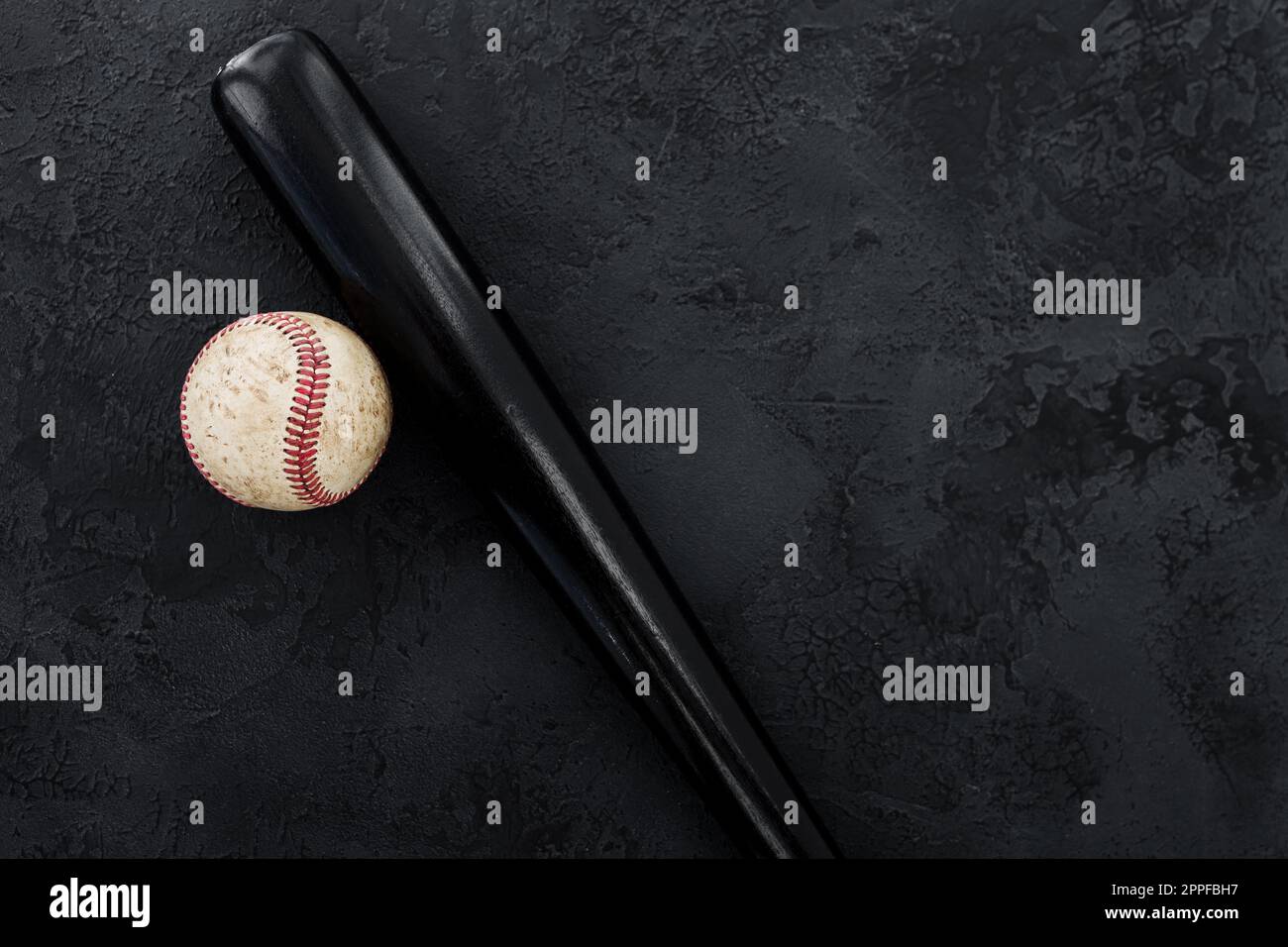 closeup of baseball bat and ball on dark background with copy space ...