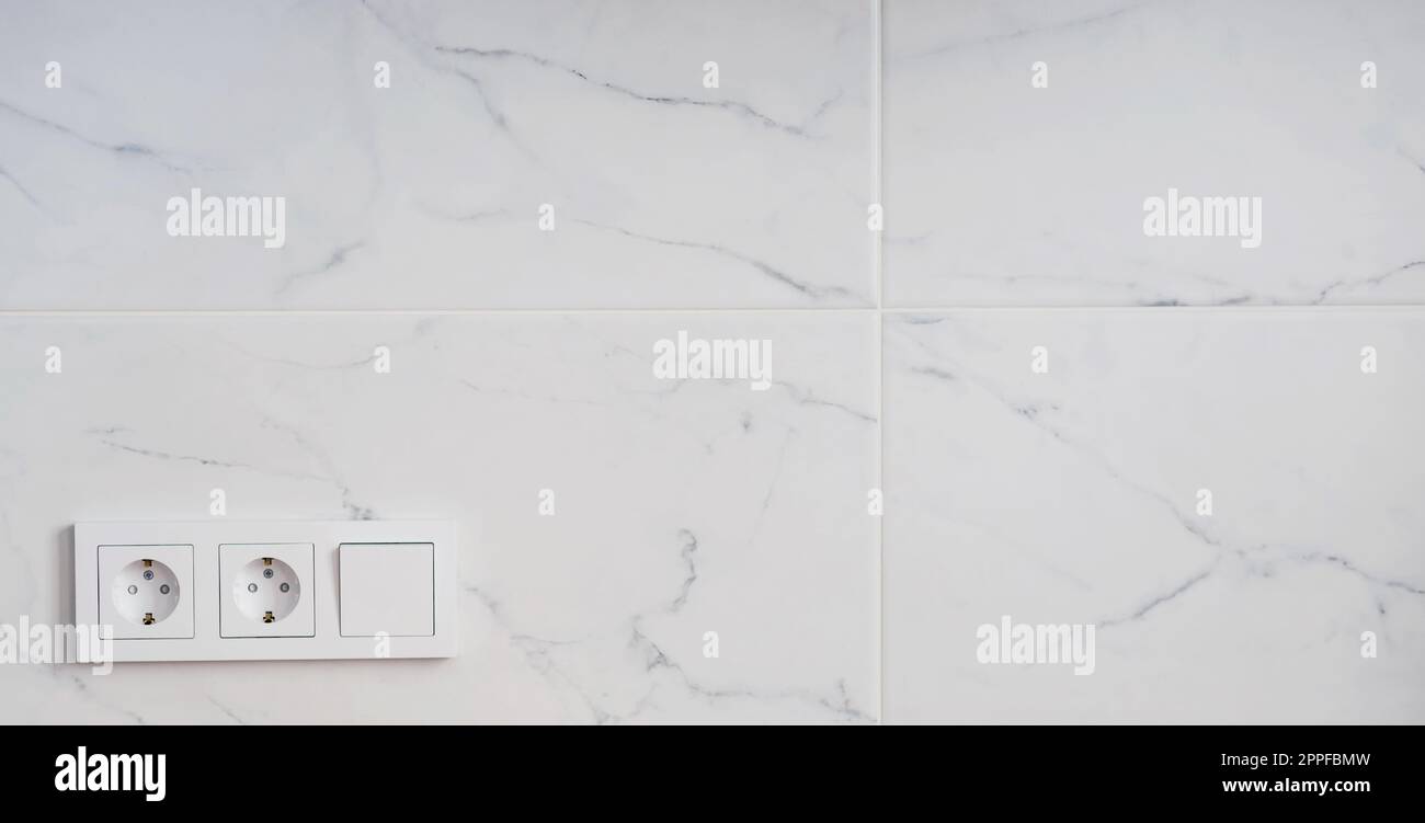 two sockets and a switch in the kitchen wall of tiles. home interior ...