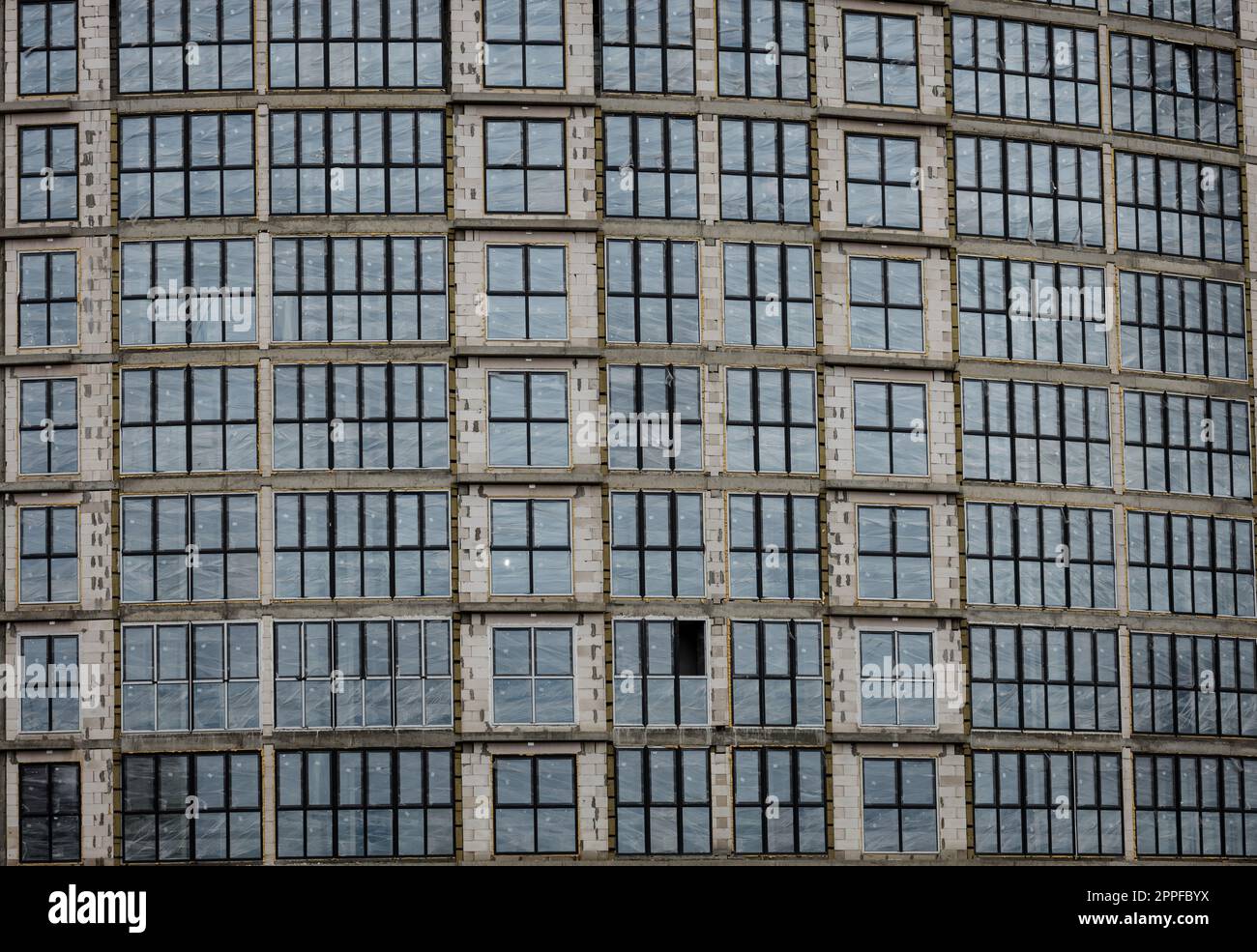 facade of a residential building under construction with many windows ...