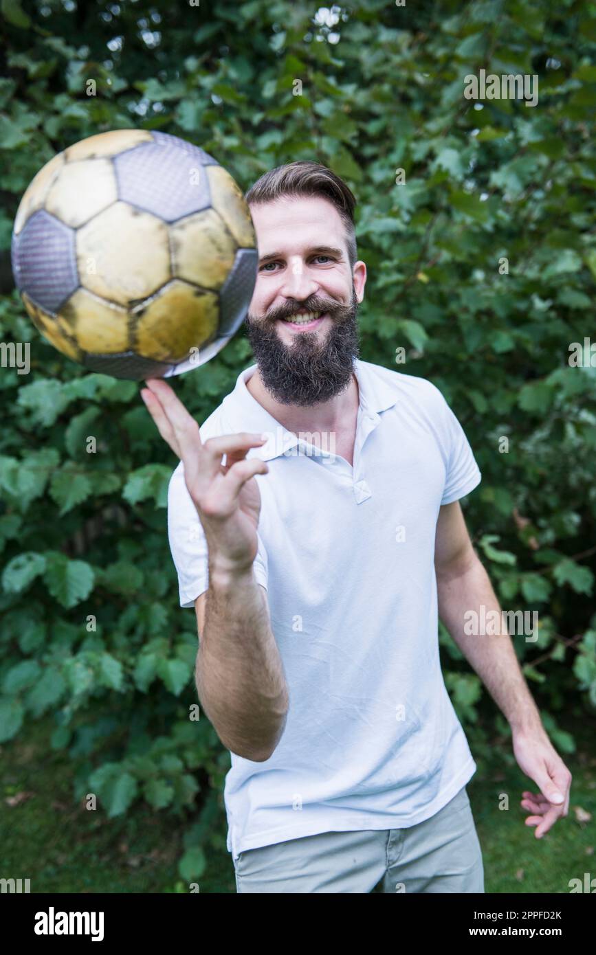 Young man balancing football on finger, Bavaria, Germany Stock Photo ...