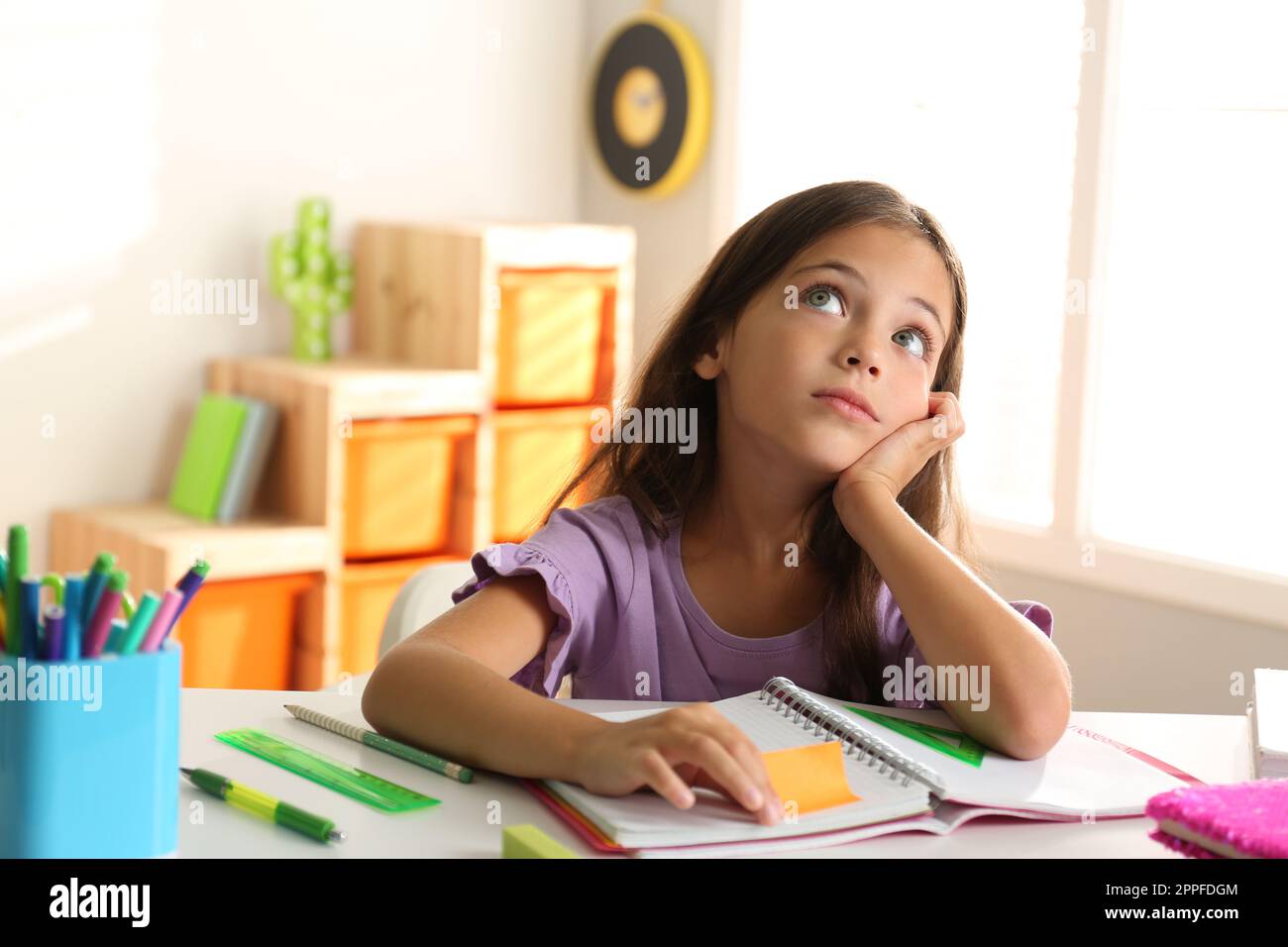 Little girl doing homework at table indoors Stock Photo - Alamy