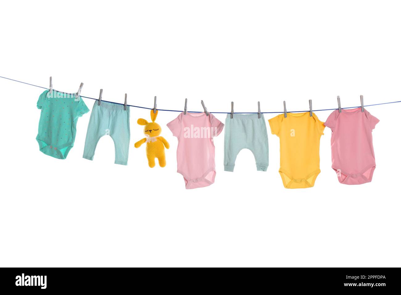 Colorful baby clothes and toy drying on laundry line against white ...