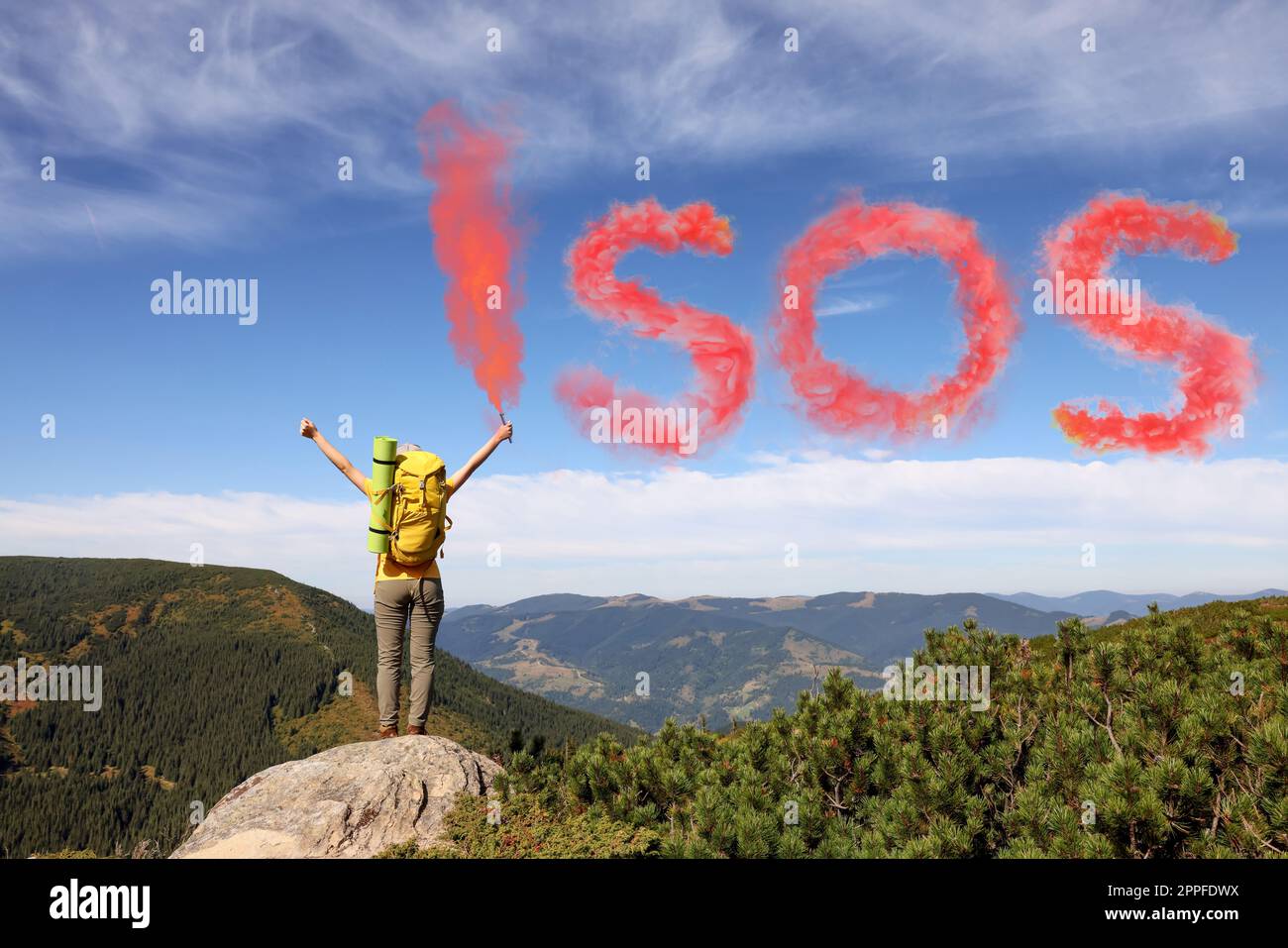 Woman with backpack and word SOS made of color smoke bomb on rocky peak ...