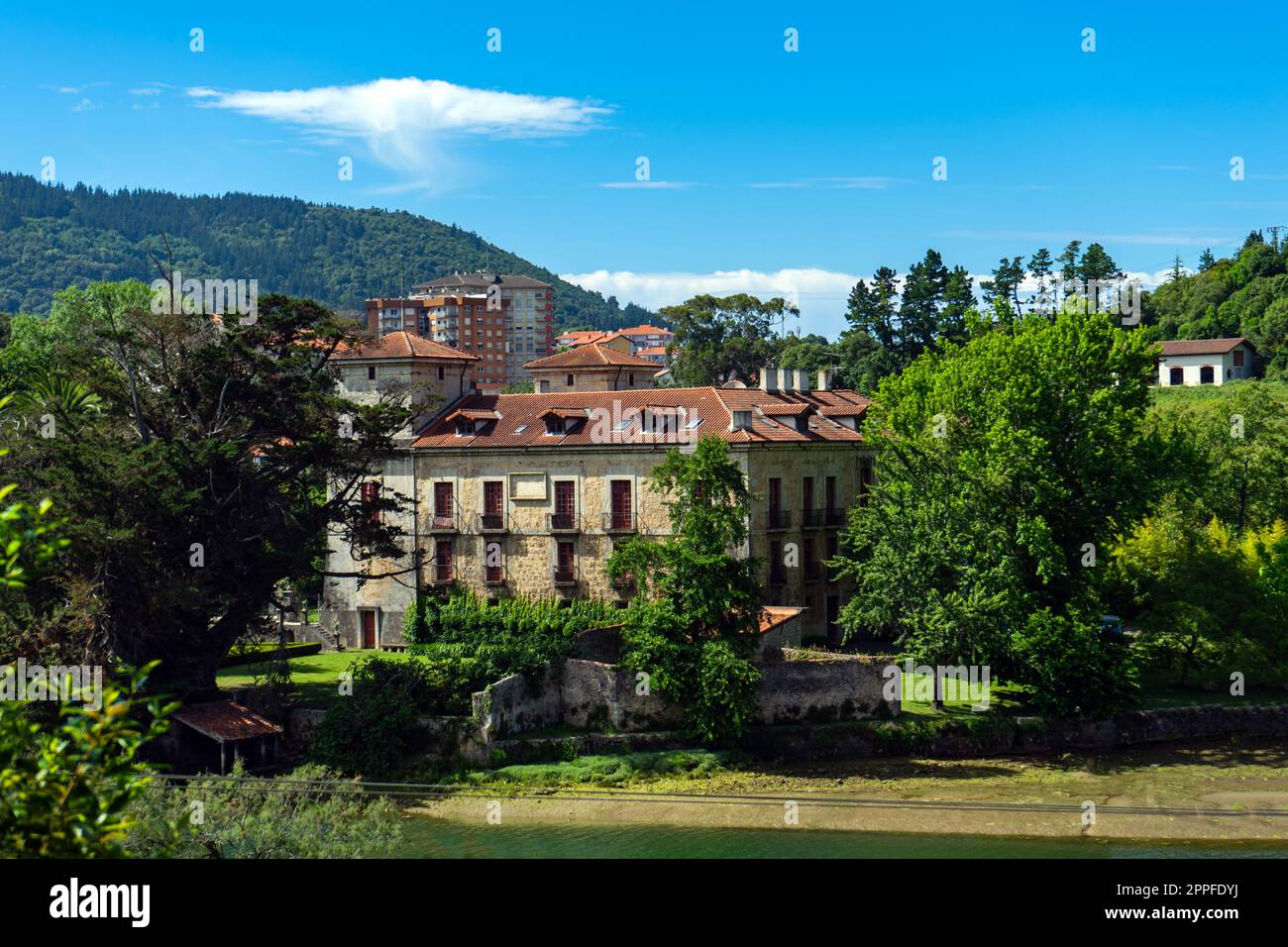 old manor house on the river bank against the background of high-rise ...