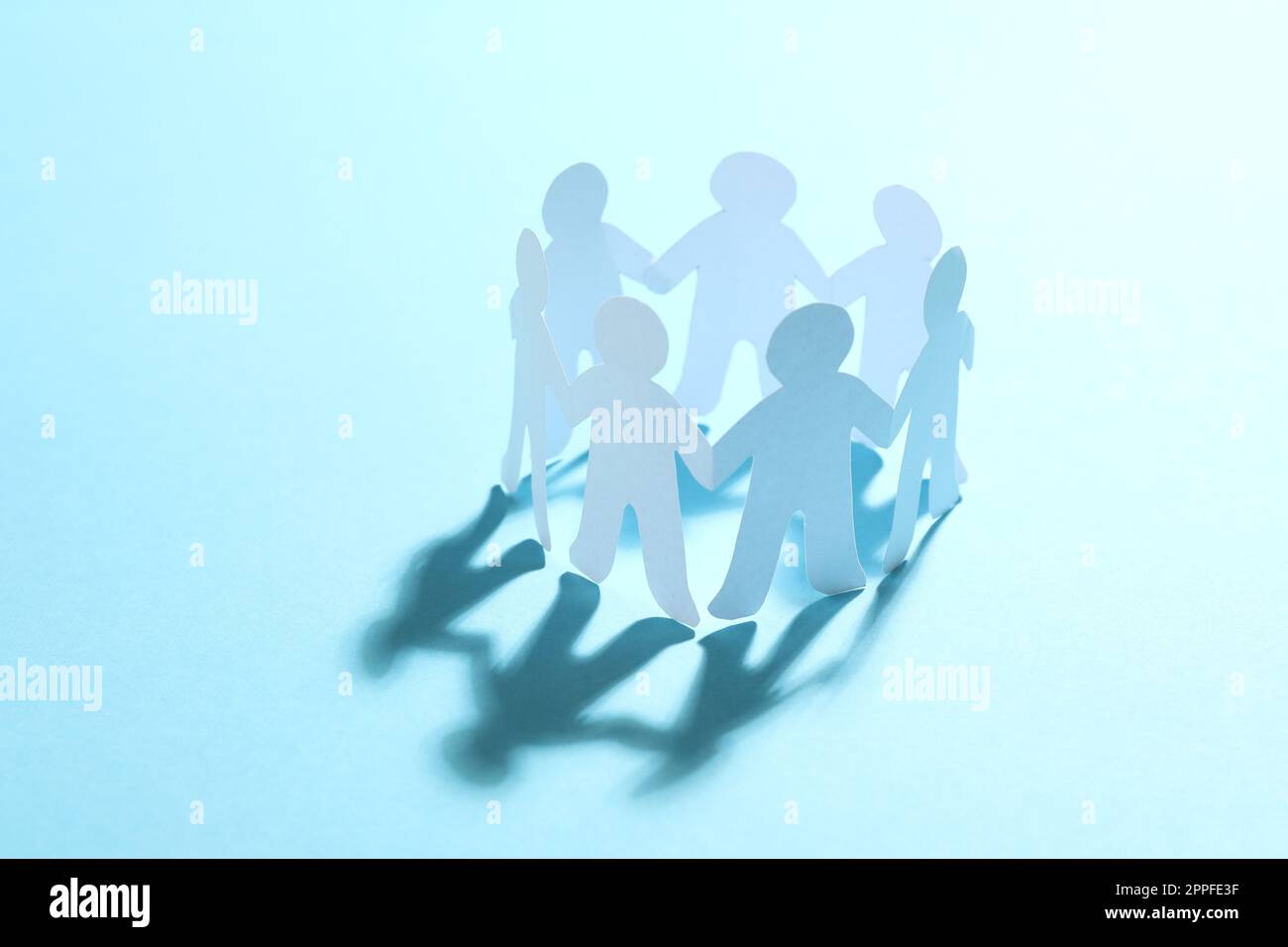 Paper people chain making circle on light blue background. Unity ...