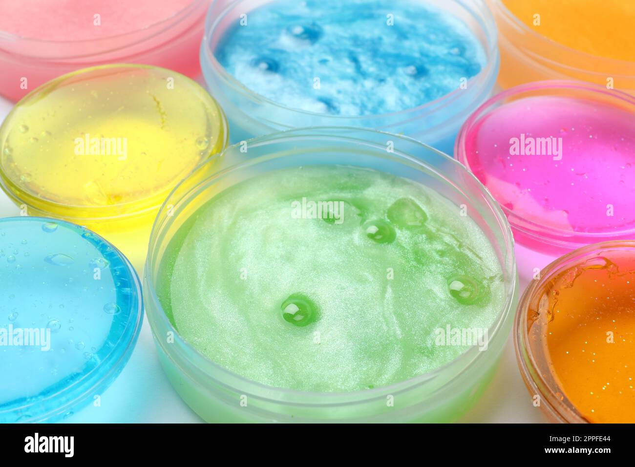 Colorful slimes in plastic containers, closeup. Antistress toy Stock ...