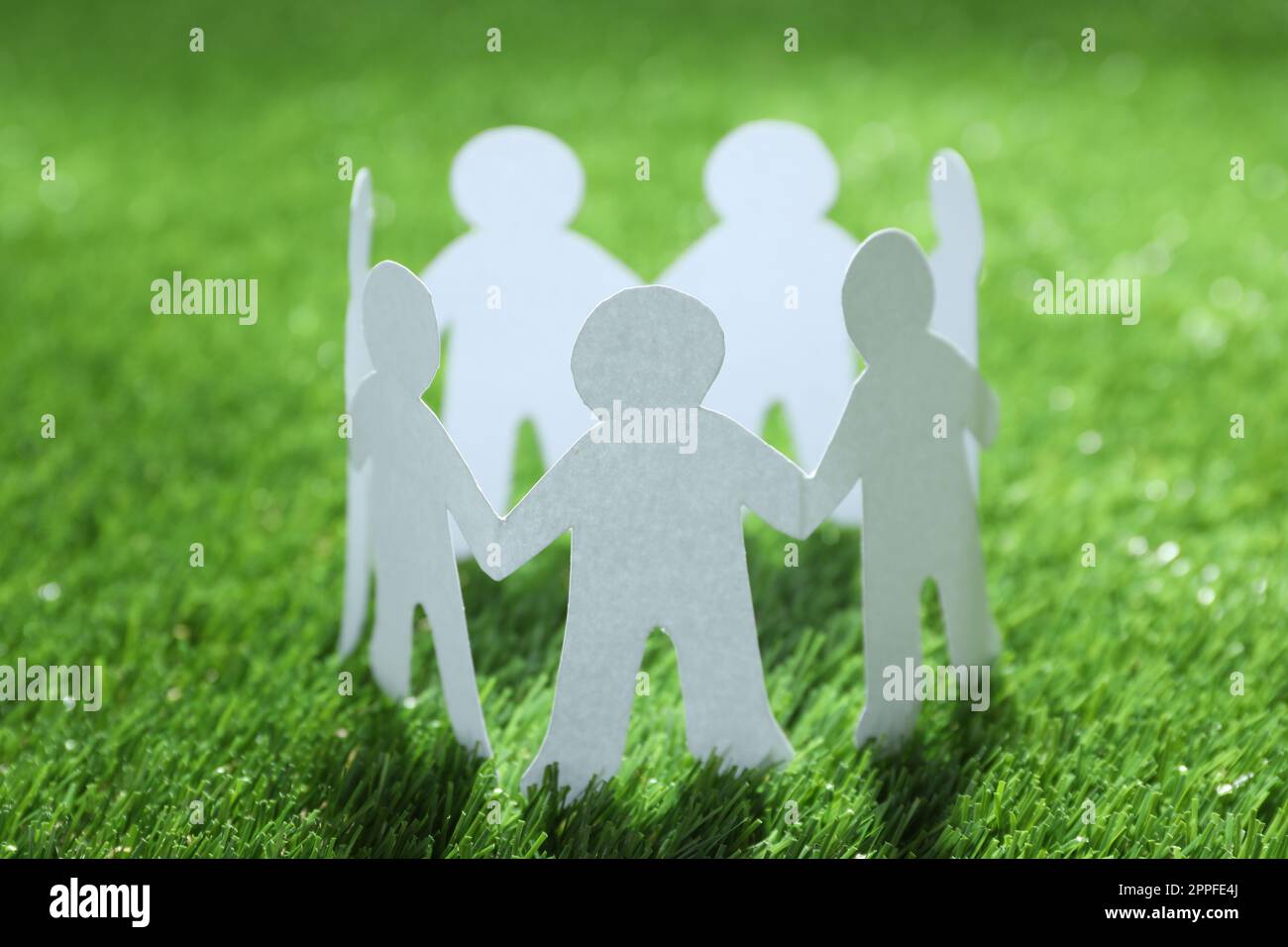 Paper people chain making circle on green grass. Unity concept Stock ...