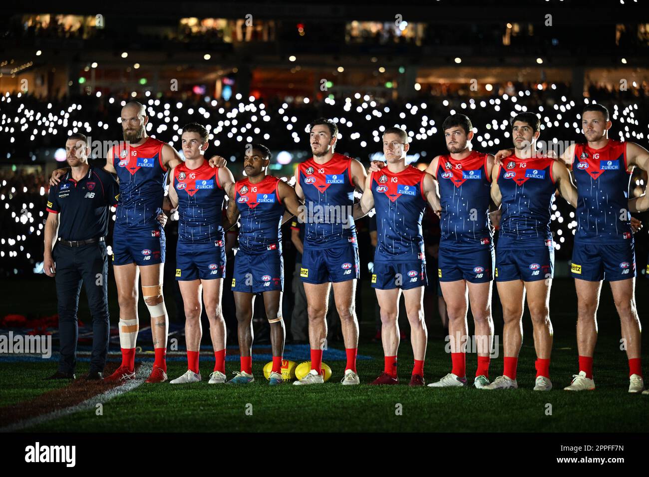 Melbourne Demons head coach Simon Goodwin (left) and players line up ...