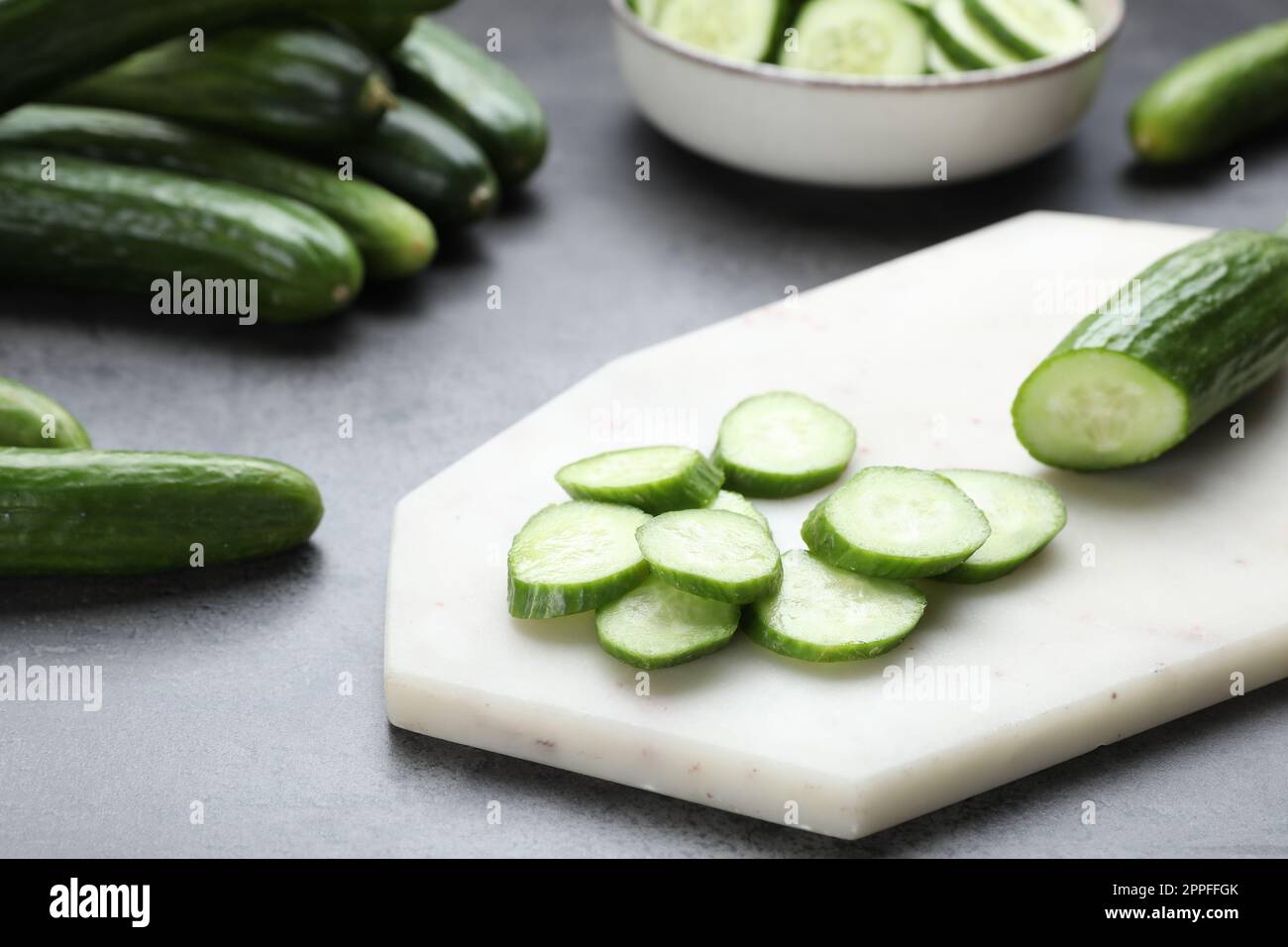Whole and cut fresh ripe cucumbers on grey table Stock Photo - Alamy