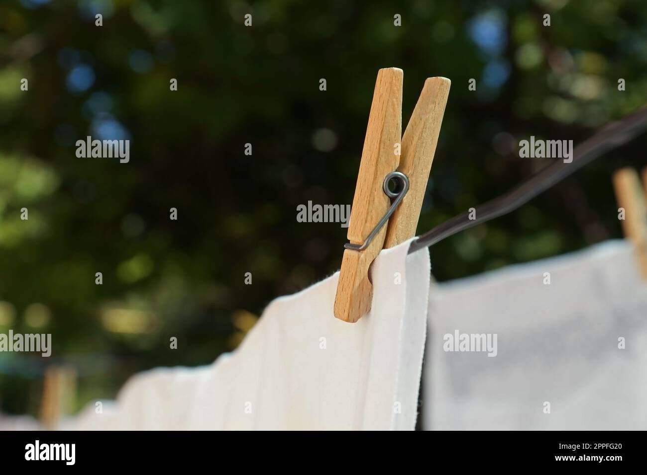 Washing line with clean laundry and clothespin outdoors, closeup Stock Photo - Alamy