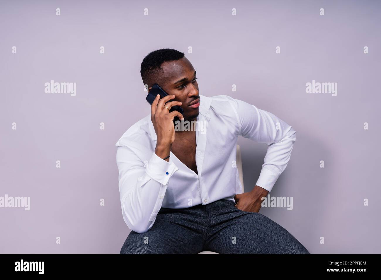 Handsome excited young african business man with mobile phone isolated ...