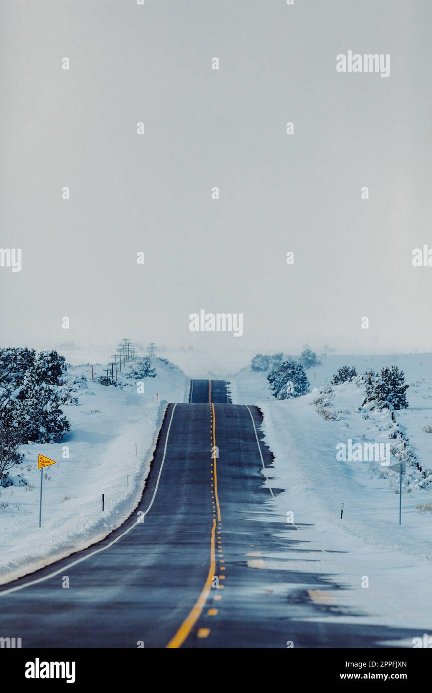 Snow covers a long road cutting through the mountains Stock Photo - Alamy