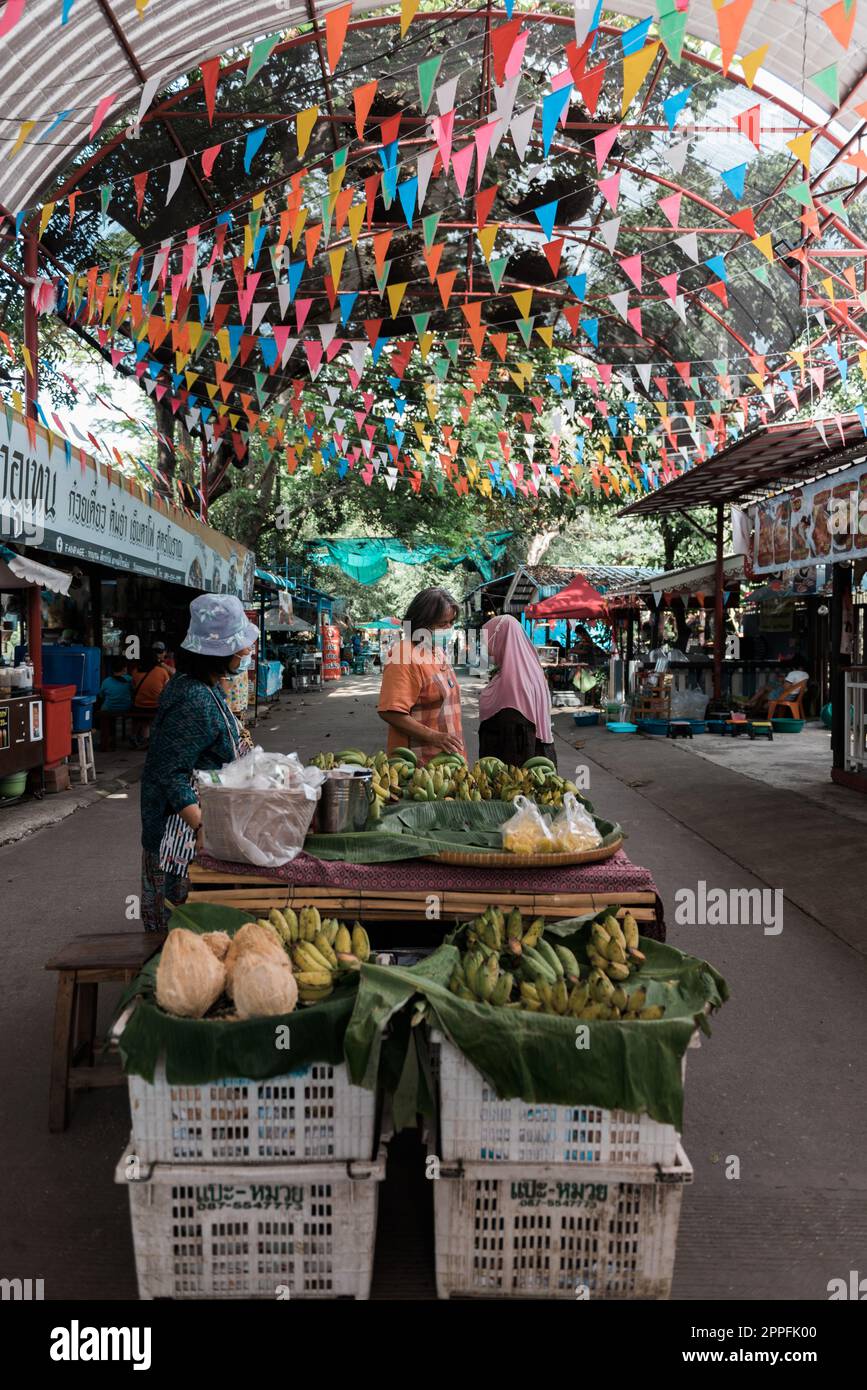 A fresh produce market with a canopy covering a variety of fruits and ...