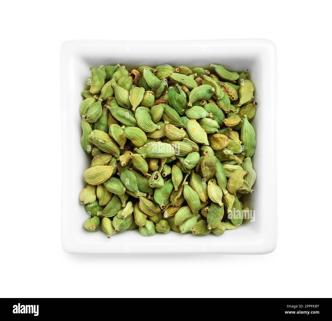 Dry cardamom pods in bowl isolated on white, top view Stock Photo - Alamy