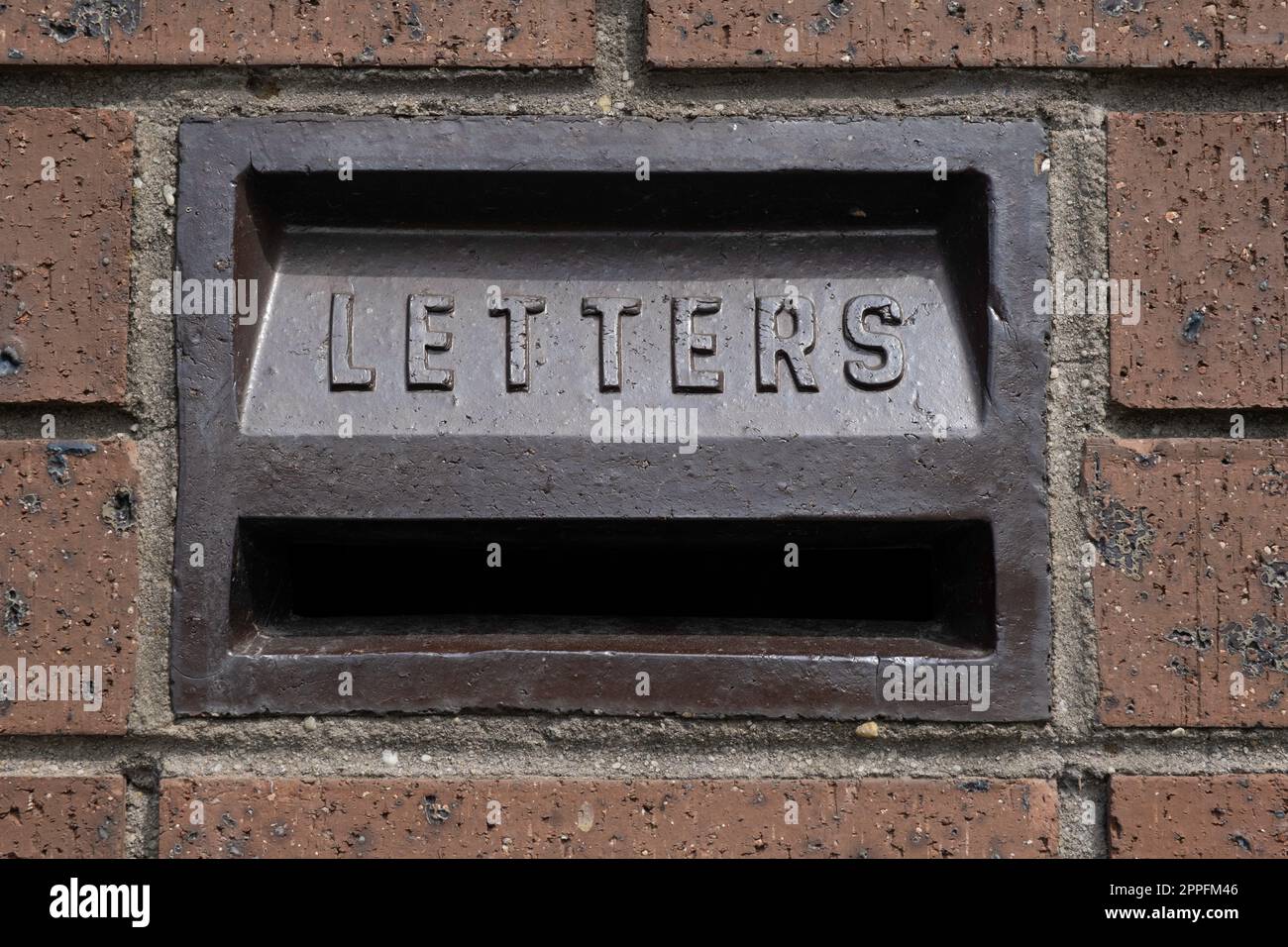 Brown painted metal mailbox with the text LETTERS bricked into a brick ...