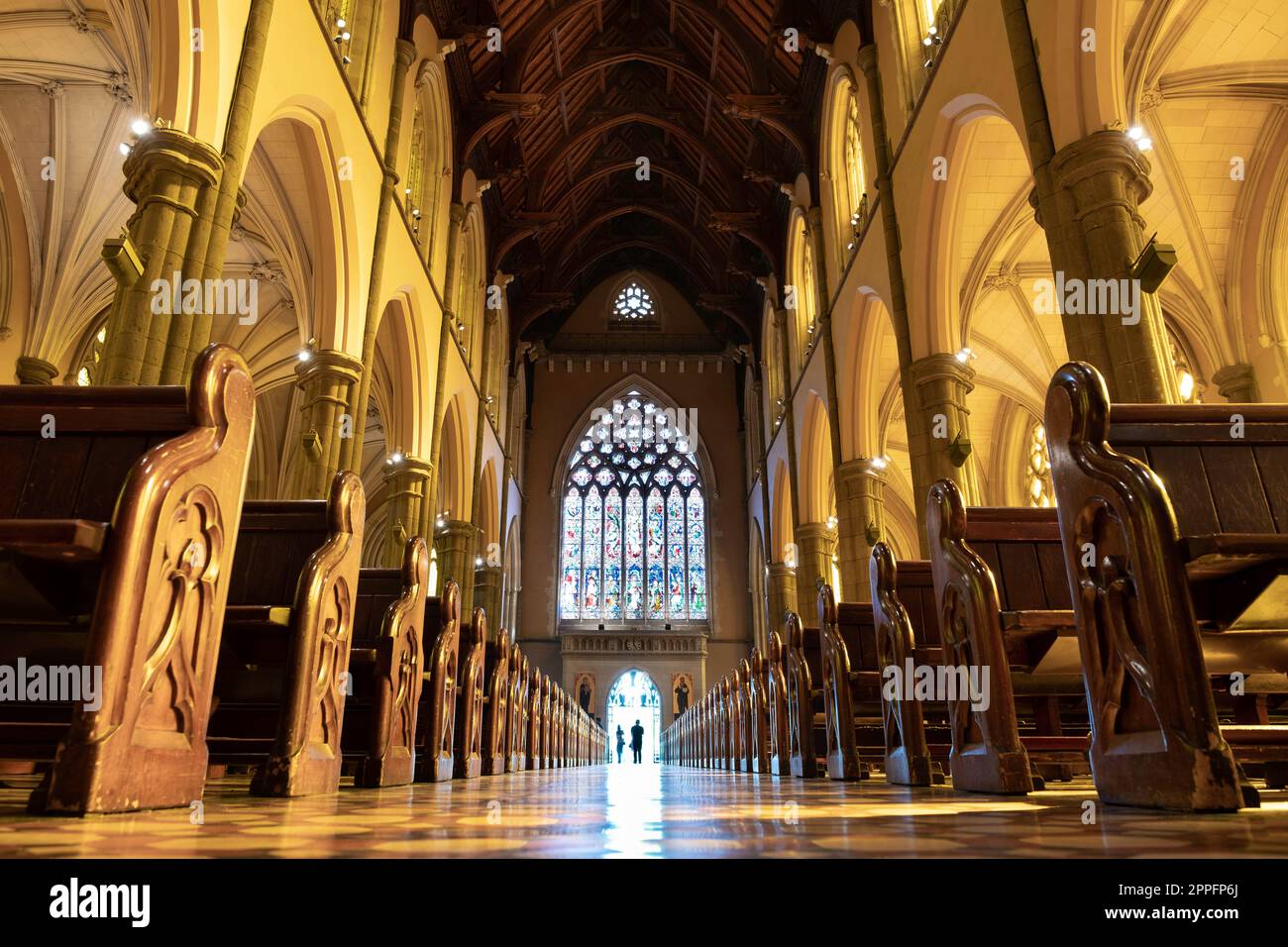 Interior with pews, large stained glass window and entrance of the Cathedral Church of Saint ...