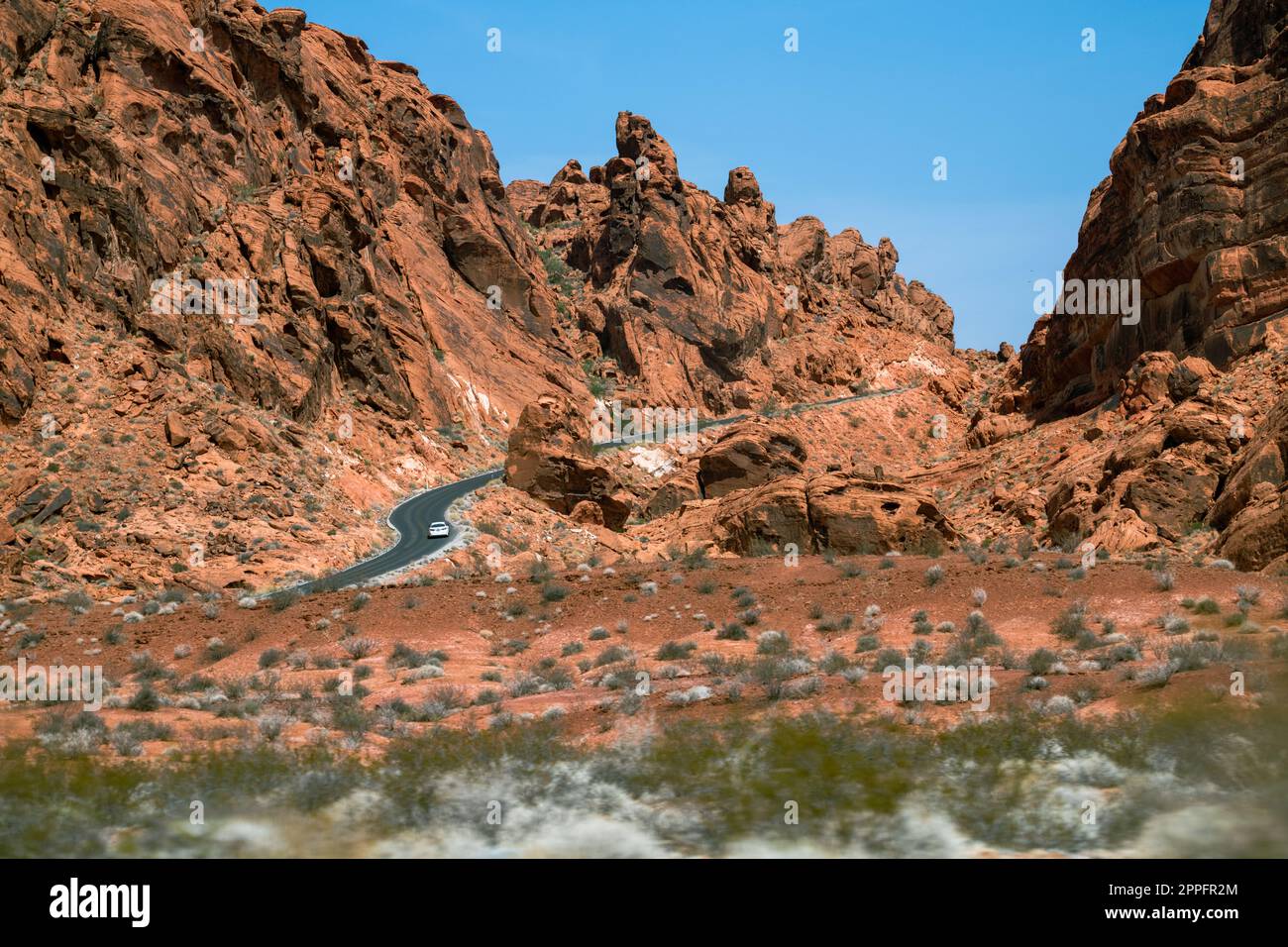 Winding road in the desert with reddish mountains in the bkgrnd Stock ...