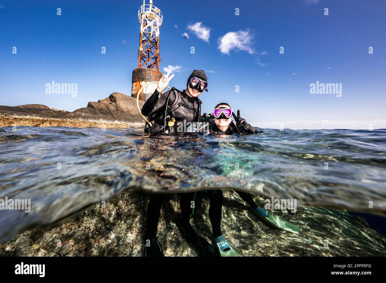 Divers surfacing at the rocky island of Losin in the Gulf of Thailand ...