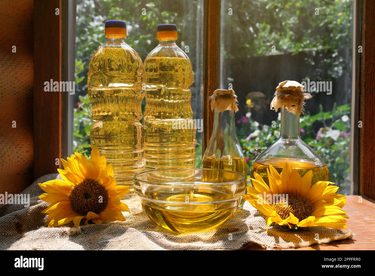 Organic sunflower oil and flowers on window sill indoors Stock Photo ...