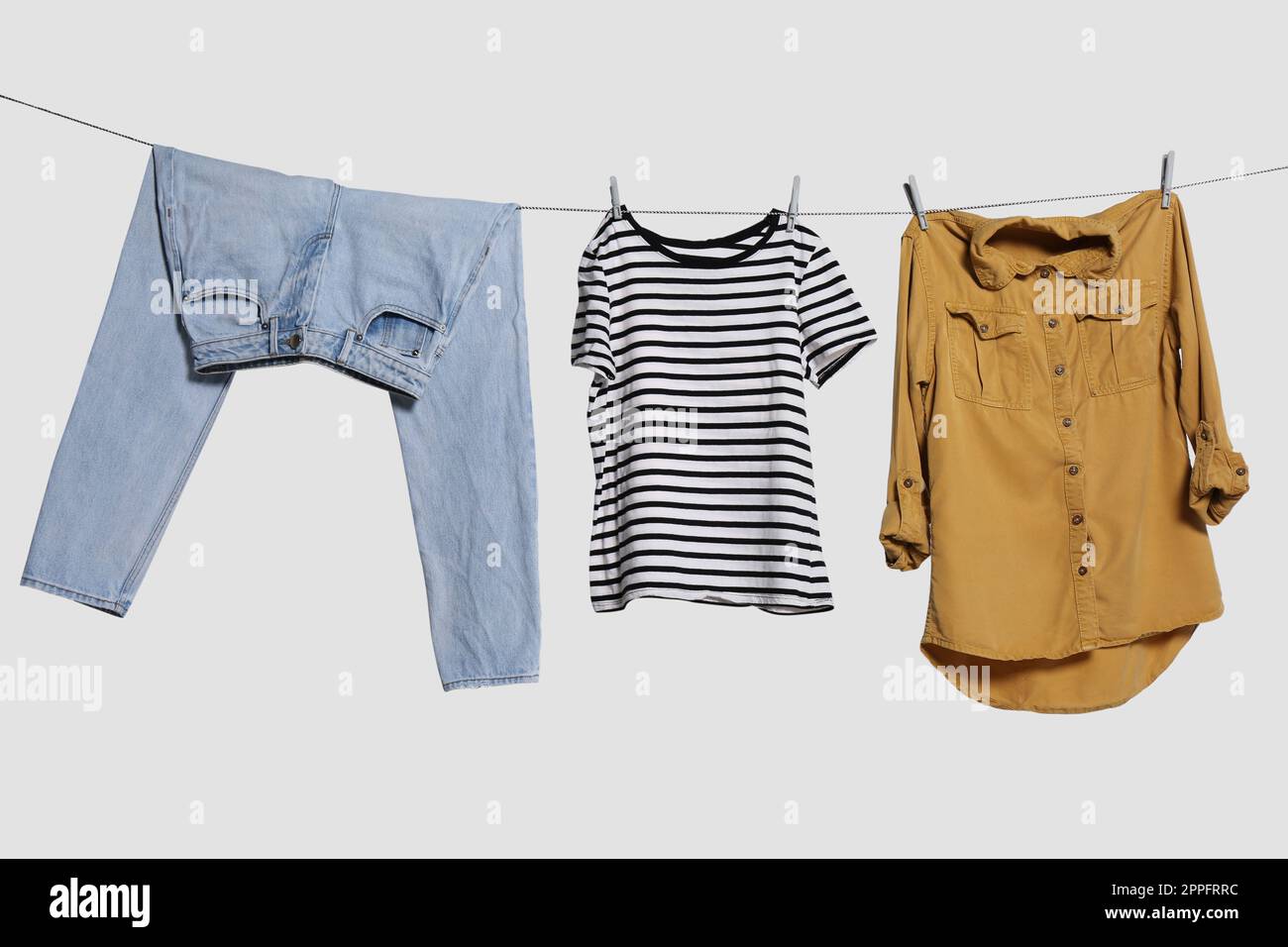 Different clothes drying on laundry line against light background Stock ...